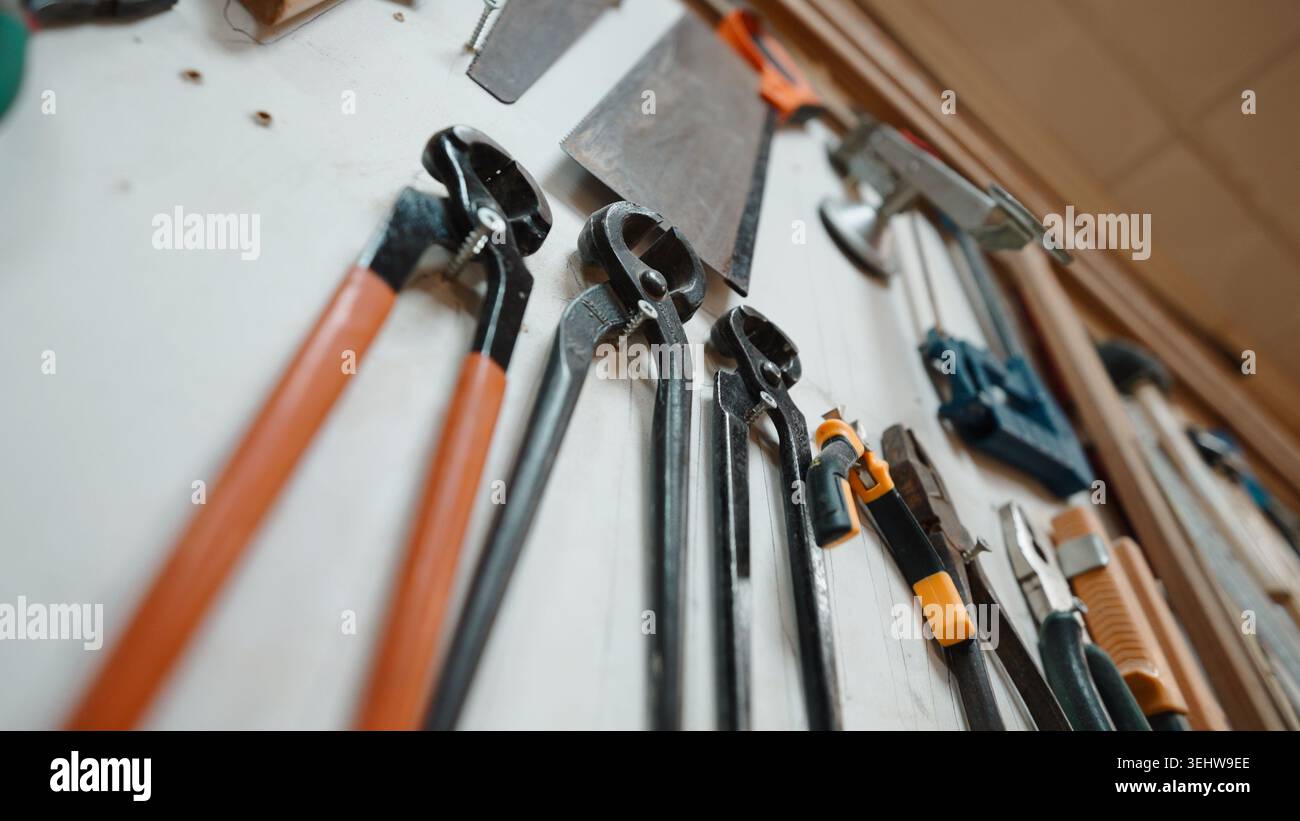Organized hand tools hanging on workshop wall, ready for carpentry and ...