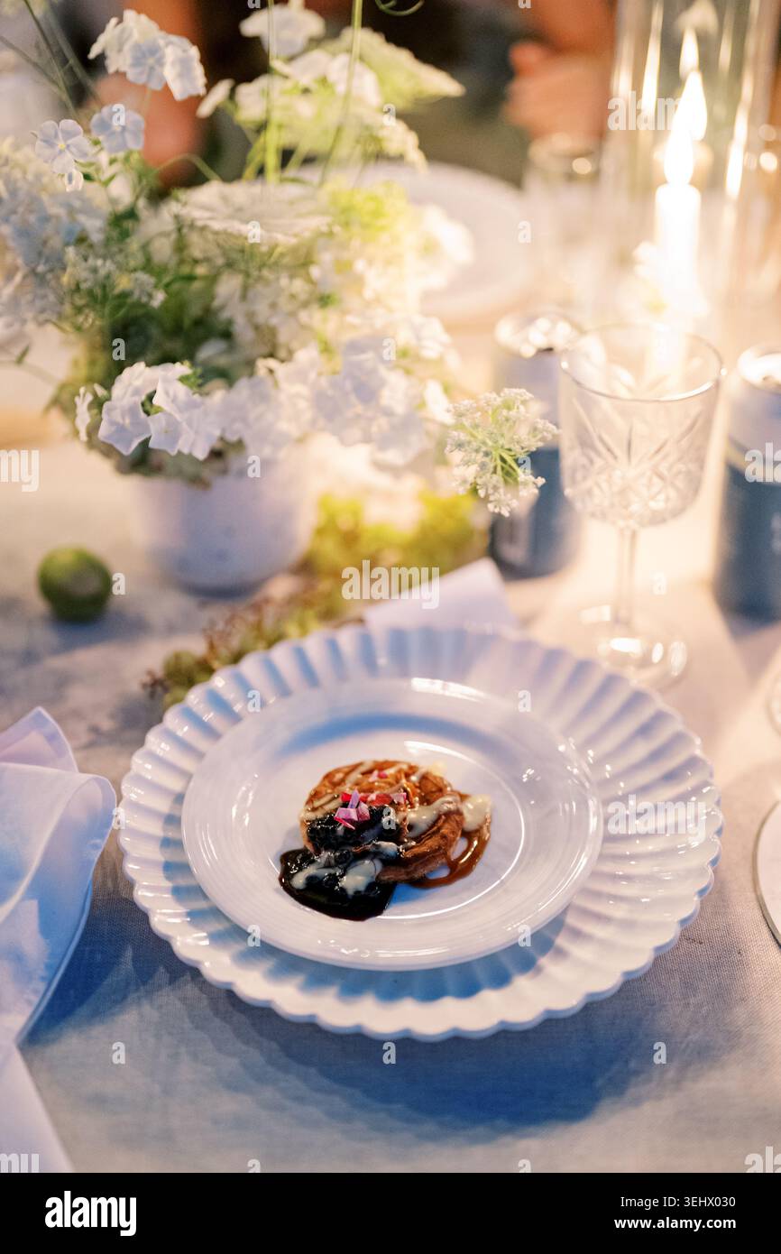 Chic dining setup. Luxurious table setting featuring delicate lights ...