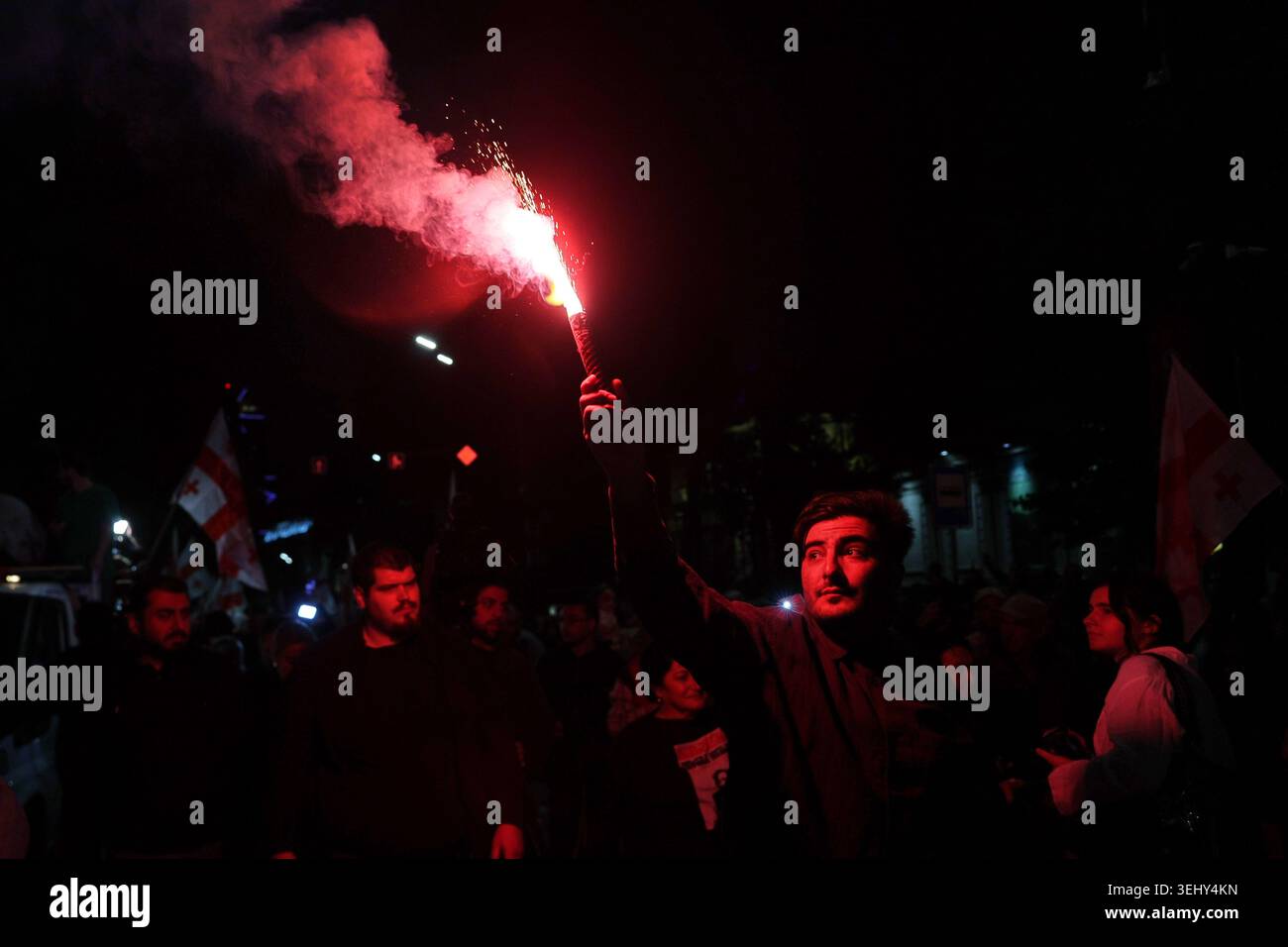A man holds a signal flare during an opposition rally marking the ...