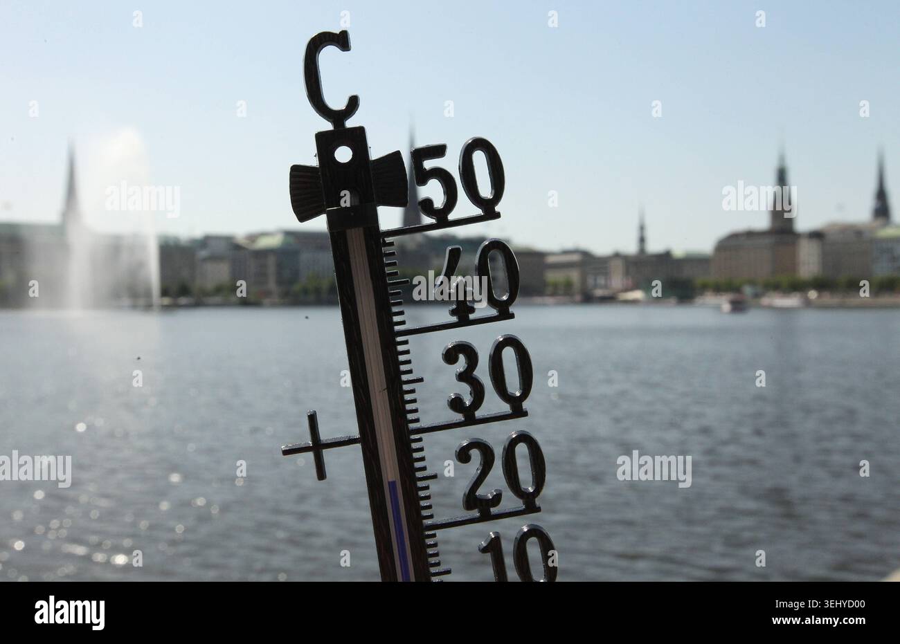 Ein Mann hält bei hochsommerlichen Temperaturen an der Binnenalster ein ...
