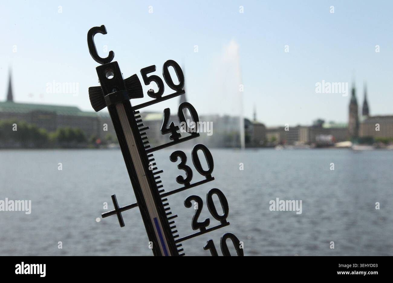 Ein Mann hält bei hochsommerlichen Temperaturen an der Binnenalster ein ...