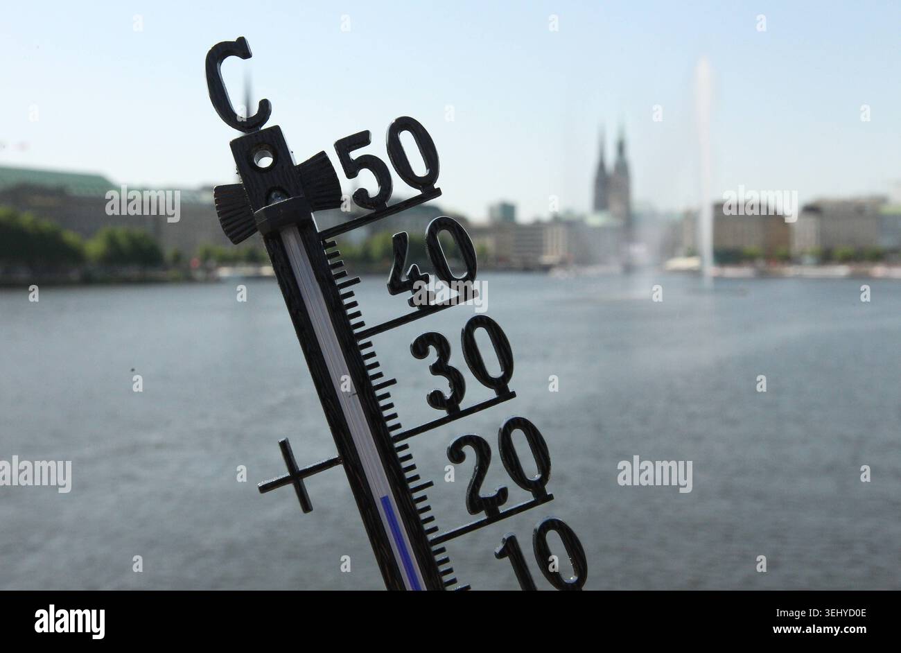 Ein Mann hält bei hochsommerlichen Temperaturen an der Binnenalster ein ...