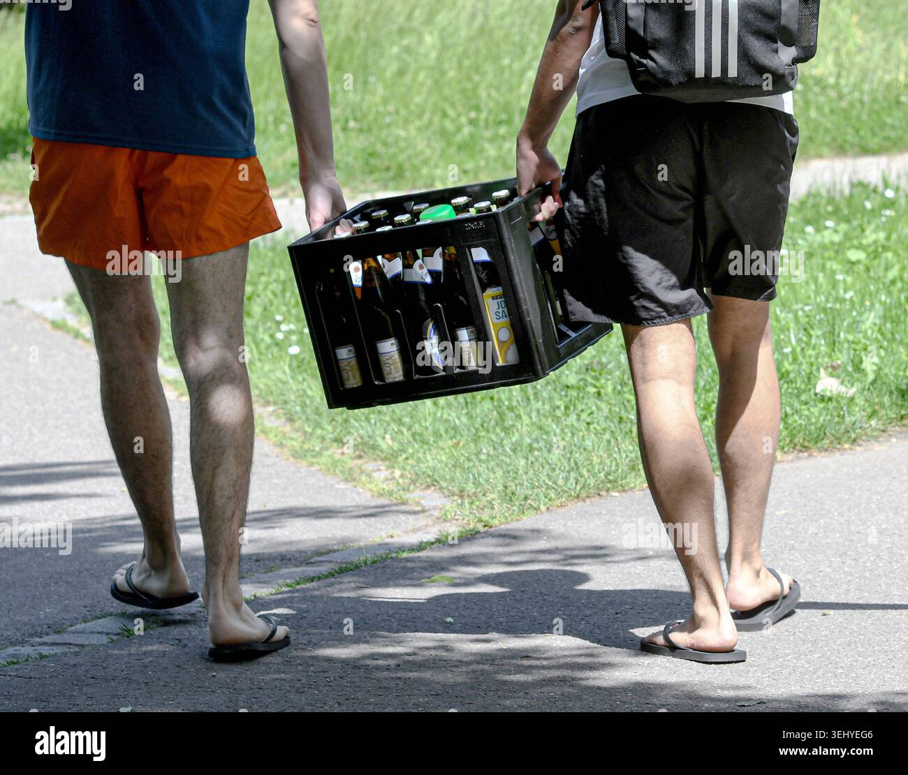 Zwei junge Maenner mit Getraenkekiste unterwegs zu einem Baggersee in ...