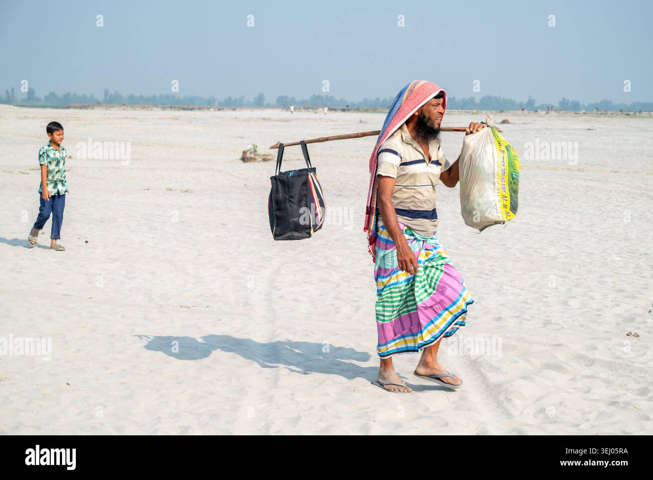 Gaibandha, Bangladesh - 15 February 2026: View of a man carrying heavy ...