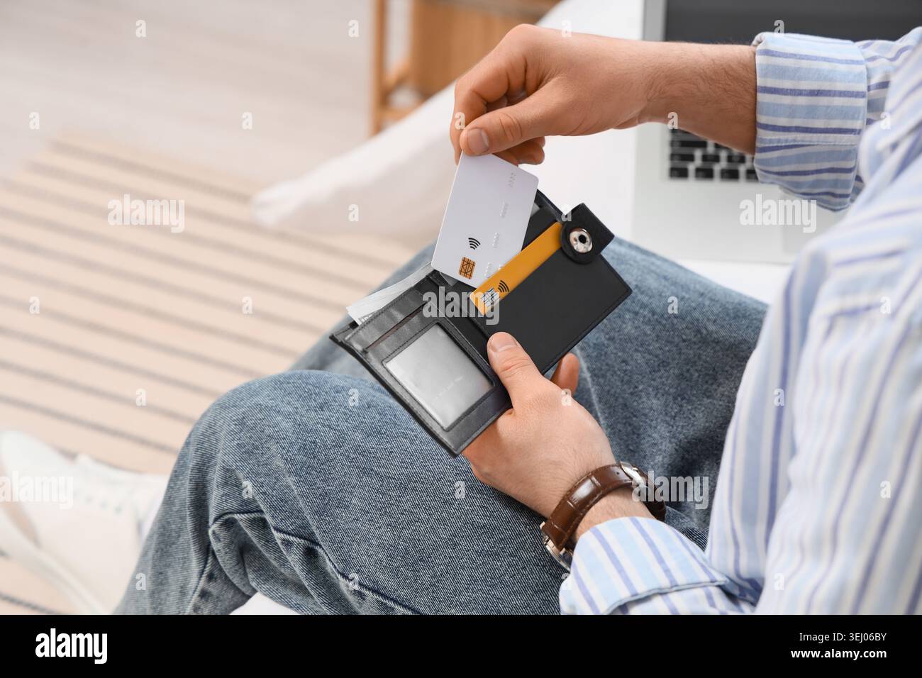 Man putting credit card into wallet in bedroom, closeup Stock Photo - Alamy