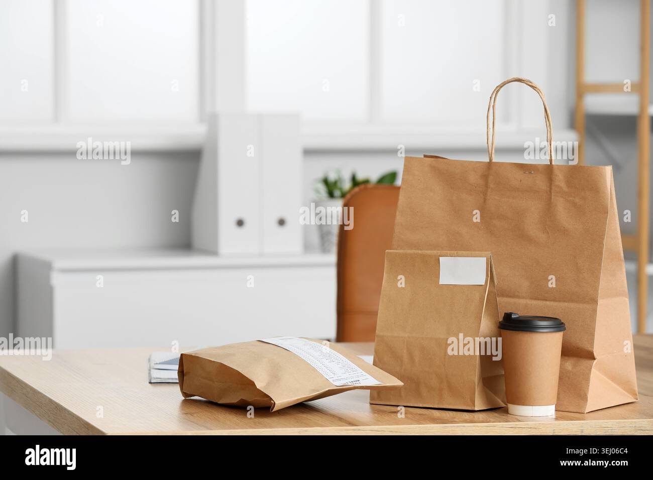 Paper bags with coffee cup on desk in office. Food delivery service ...