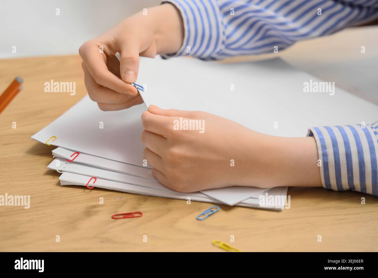 Female hands stapling documents with paper clip on desk in office ...