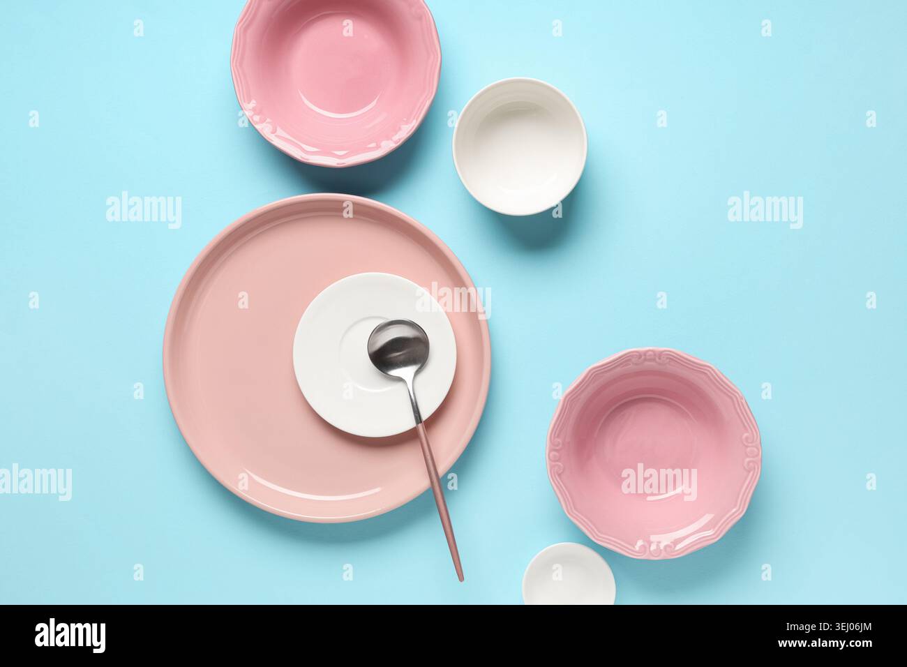 Different plates with bowls and spoon on blue background Stock Photo ...