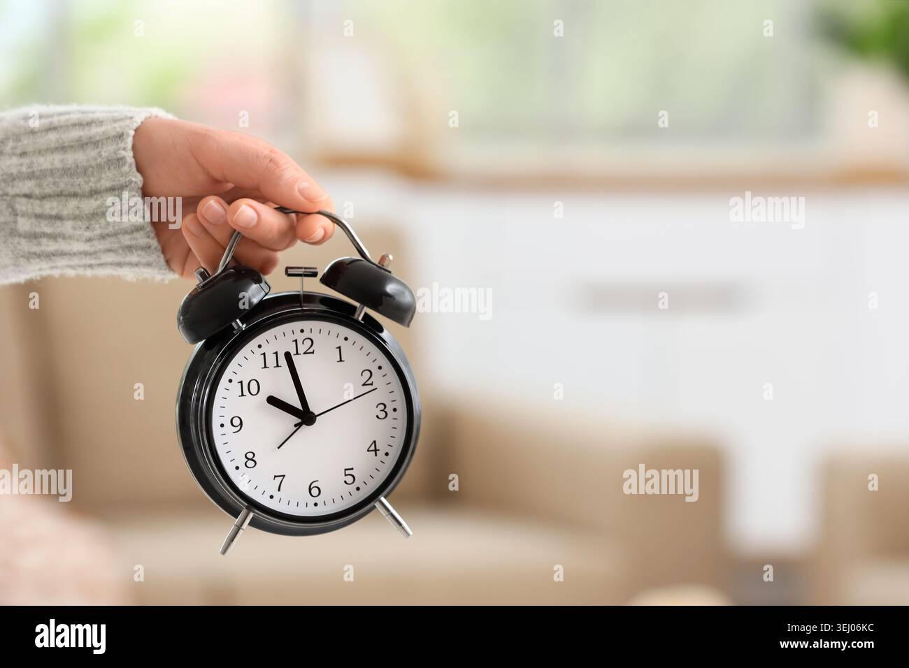 Female hand with alarm clock at home, closeup. Daylight saving time ...