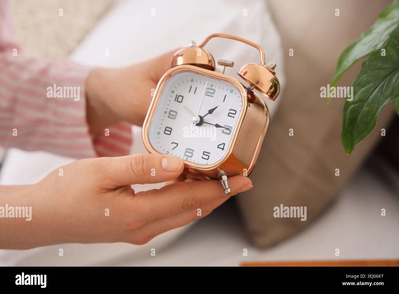 Female hands with alarm clock in bedroom, closeup. Daylight saving time ...