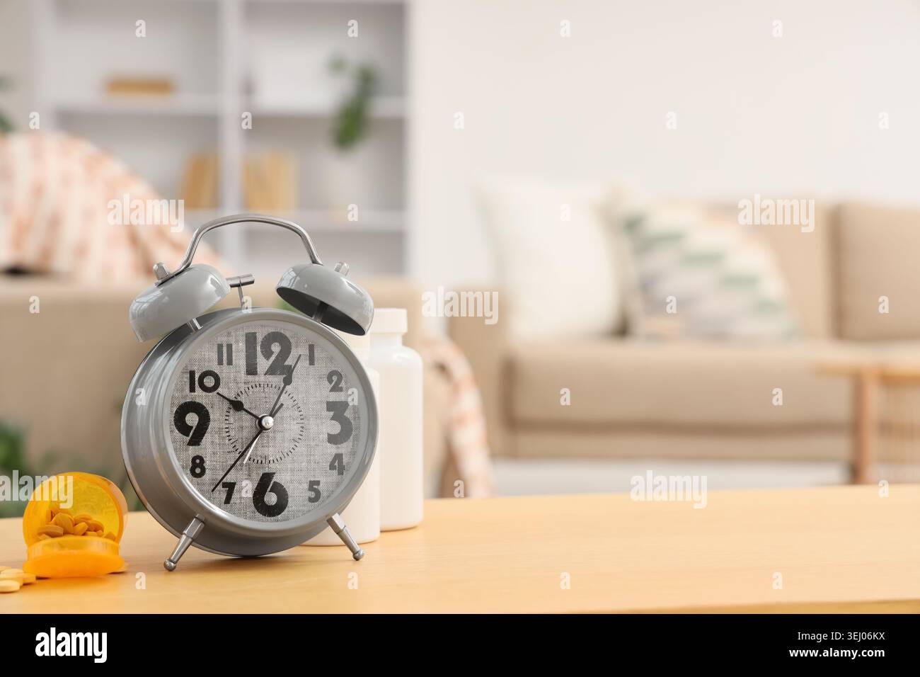 Alarm clock with pill bottles on table in room, closeup Stock Photo - Alamy