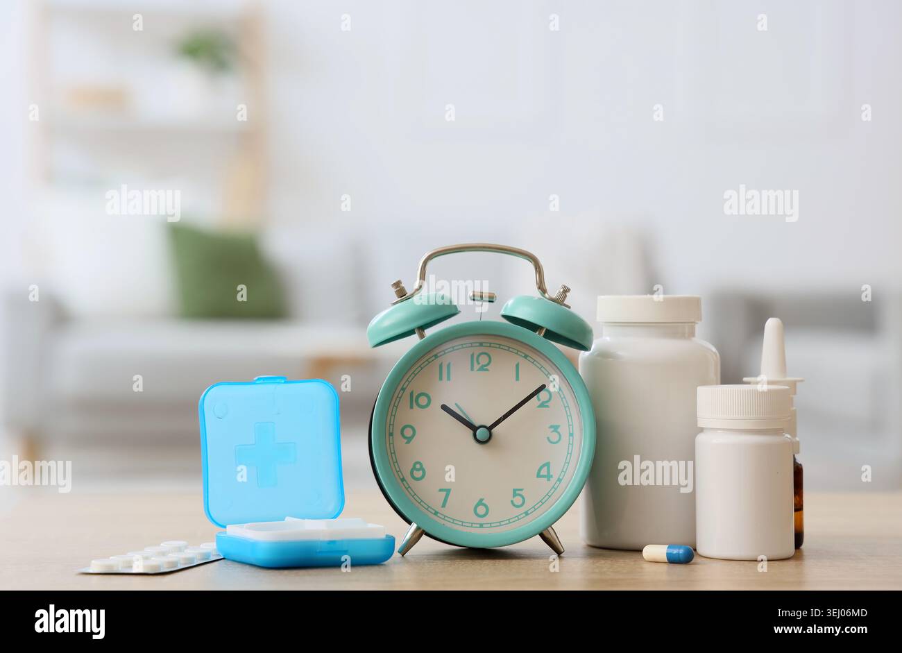 Alarm clock with pills on table in room Stock Photo - Alamy