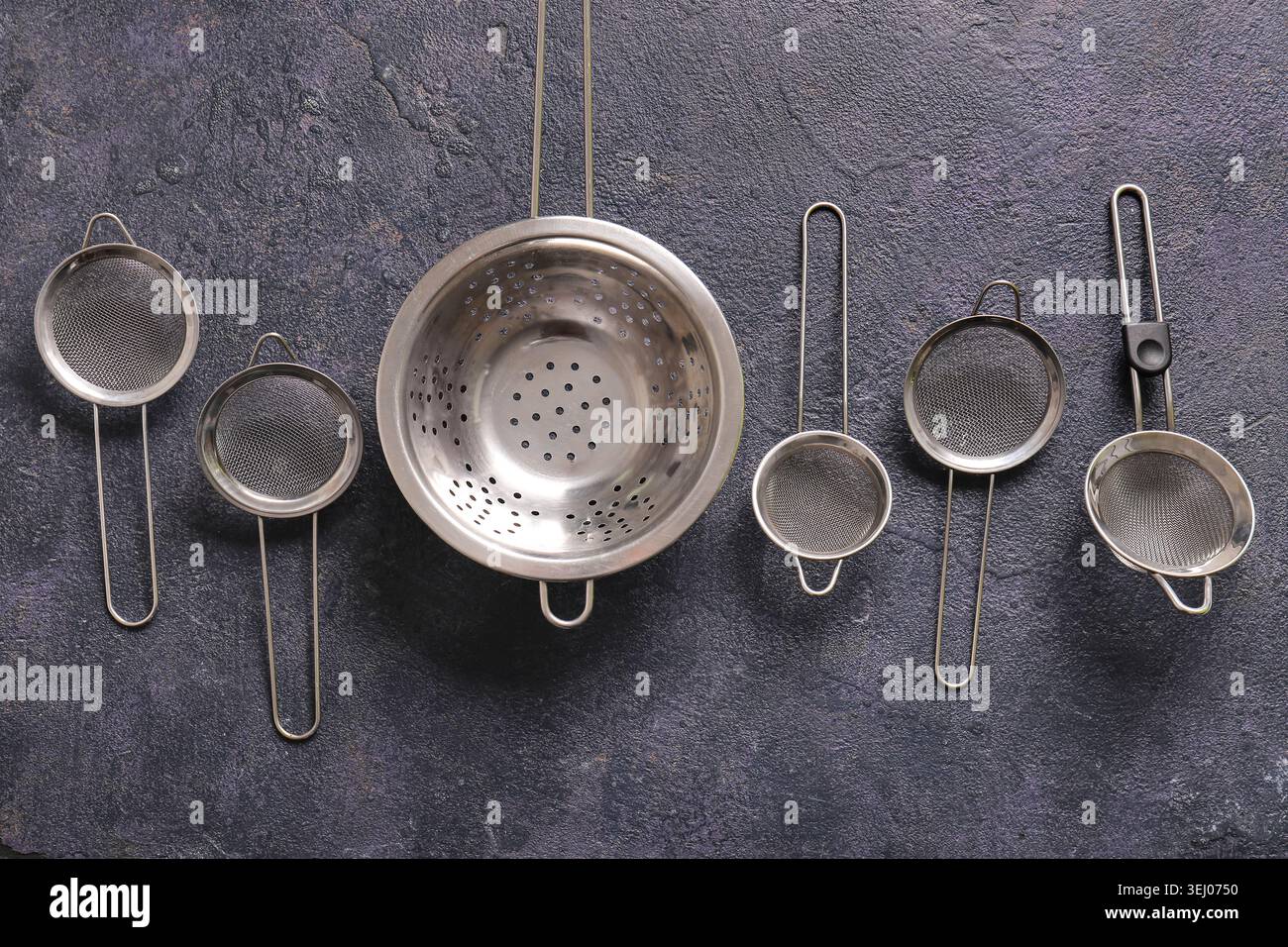Different sieves with colander on grey grunge background Stock Photo ...