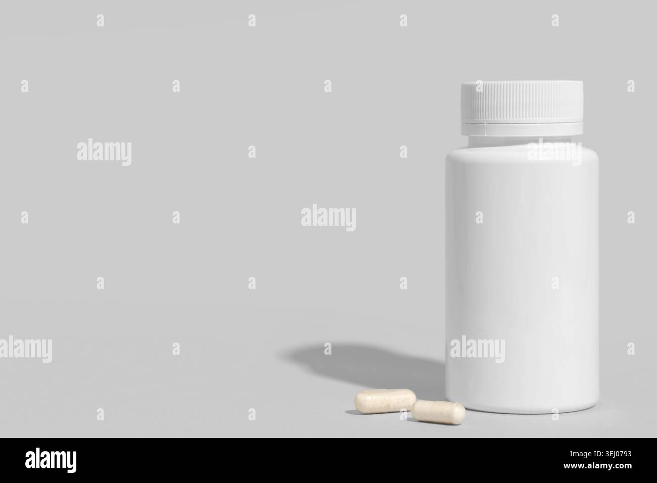 Blank plastic vitamin bottle and pills on grey background Stock Photo ...