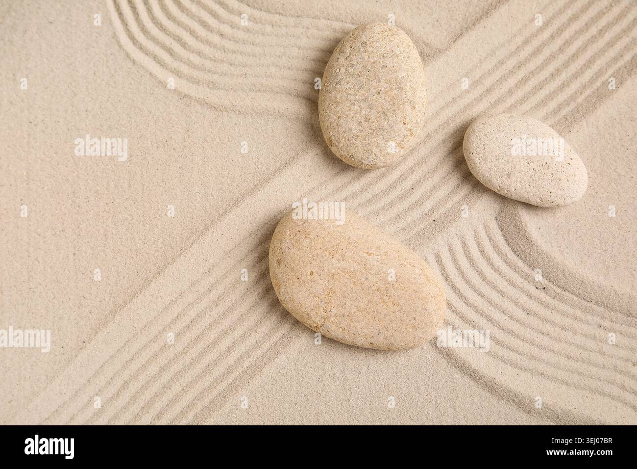 Composition with spa stones and lines on sand as background, closeup ...