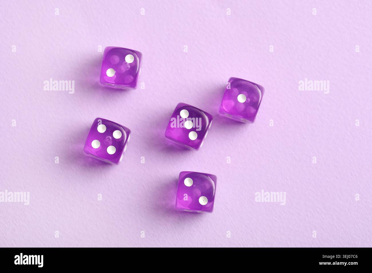 Purple game dices on lilac background Stock Photo - Alamy