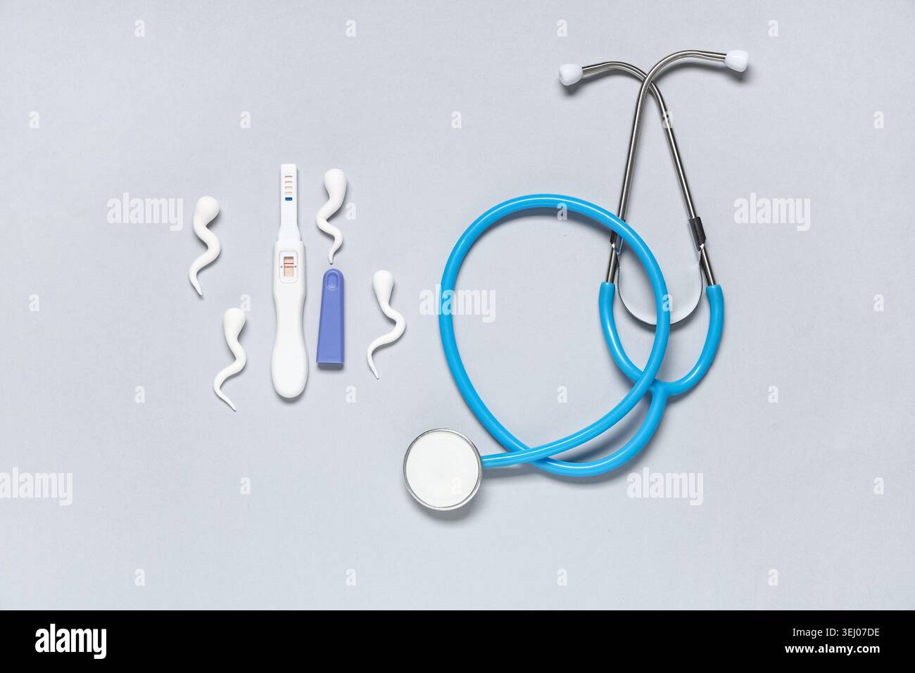 Sperm cells with stethoscope and pregnancy test on grey background ...