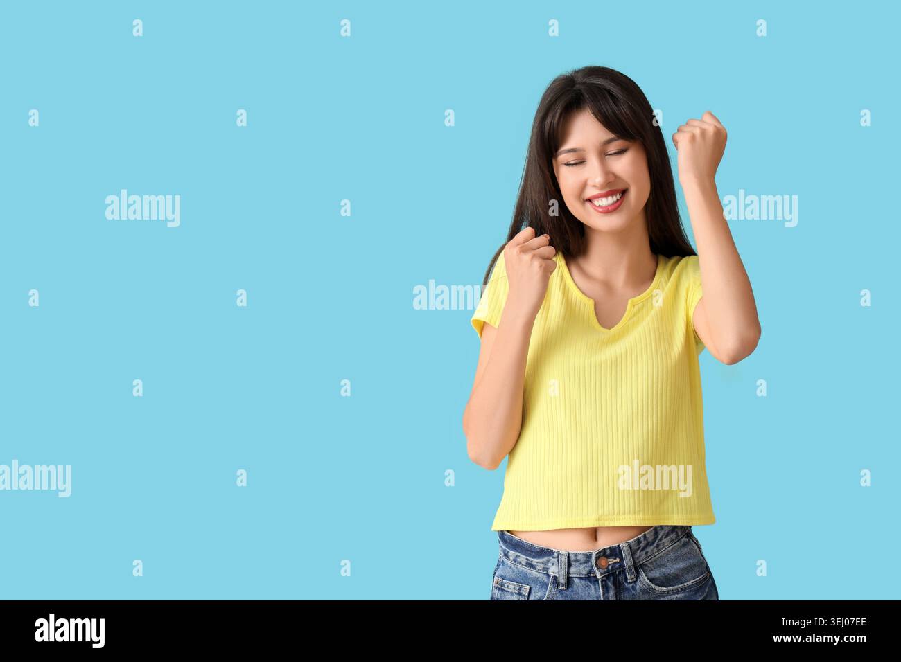 Smiling young woman on blue background Stock Photo - Alamy