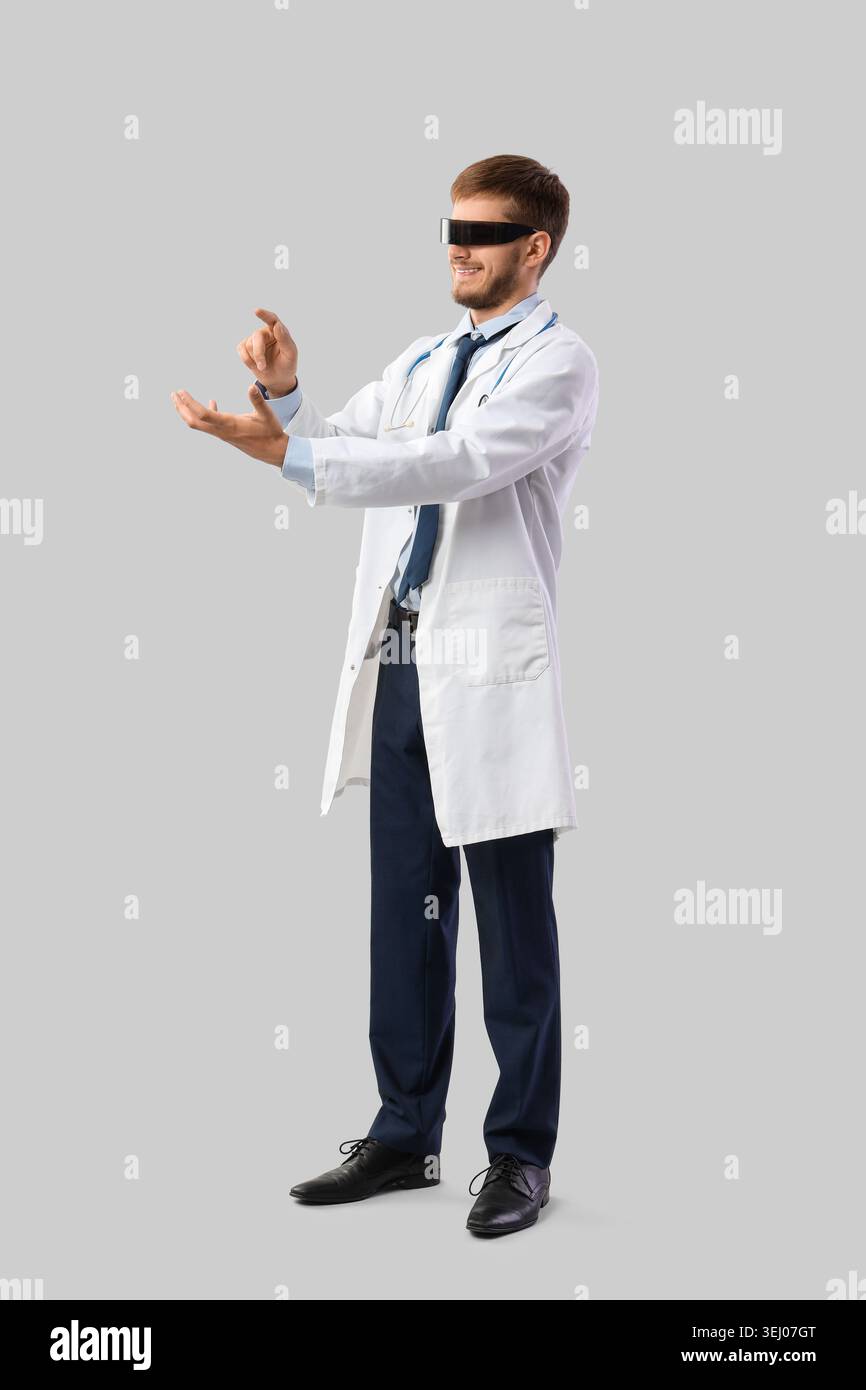 Male doctor in AR glasses using virtual screen on light background ...