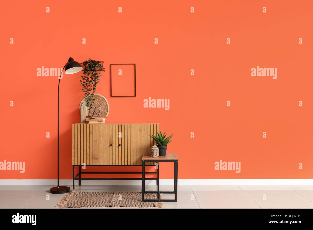 Chest of drawers, floor lamp and table in interior of living room Stock ...