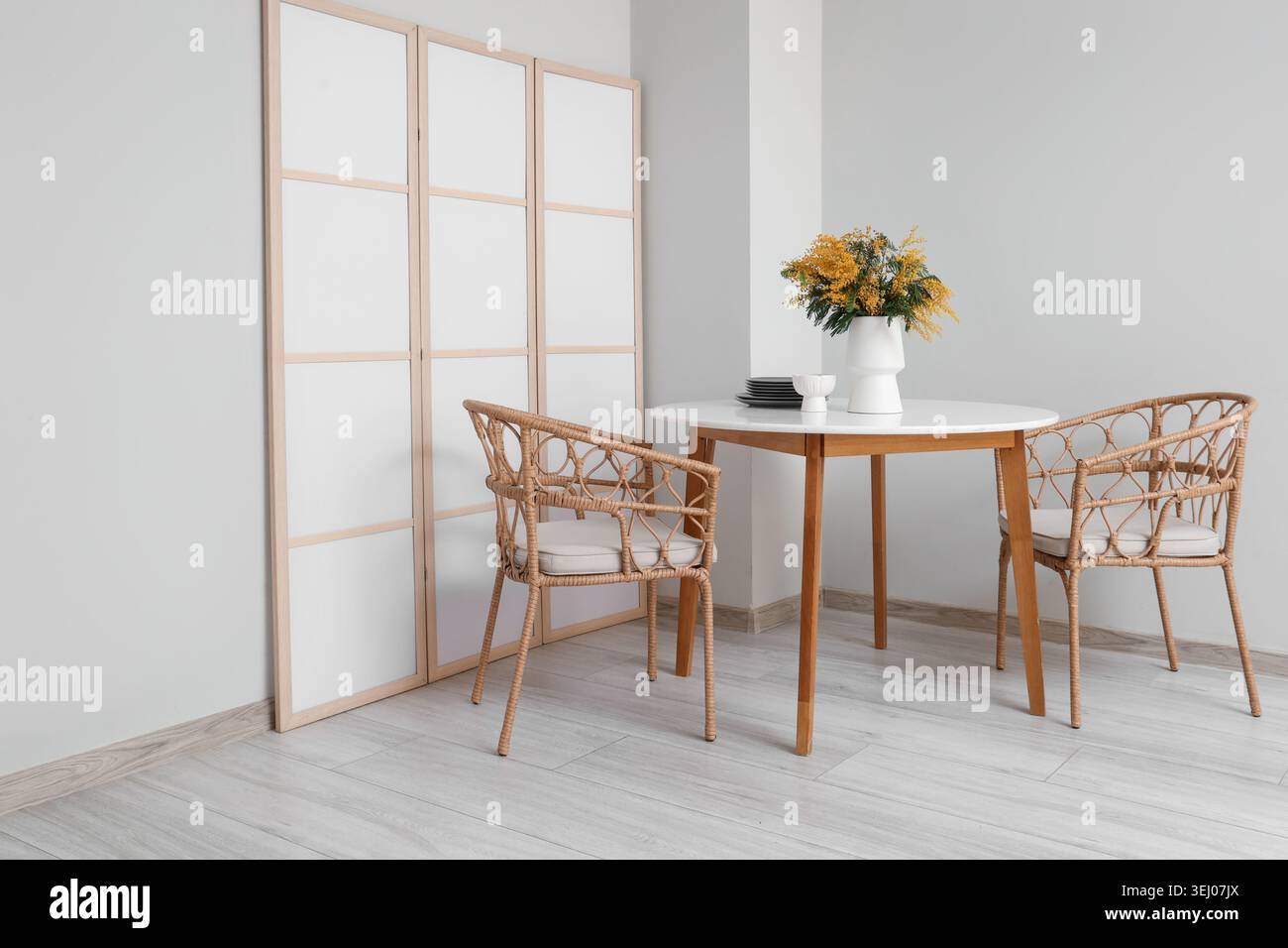Vase with mimosa flowers on dining table in light room Stock Photo - Alamy
