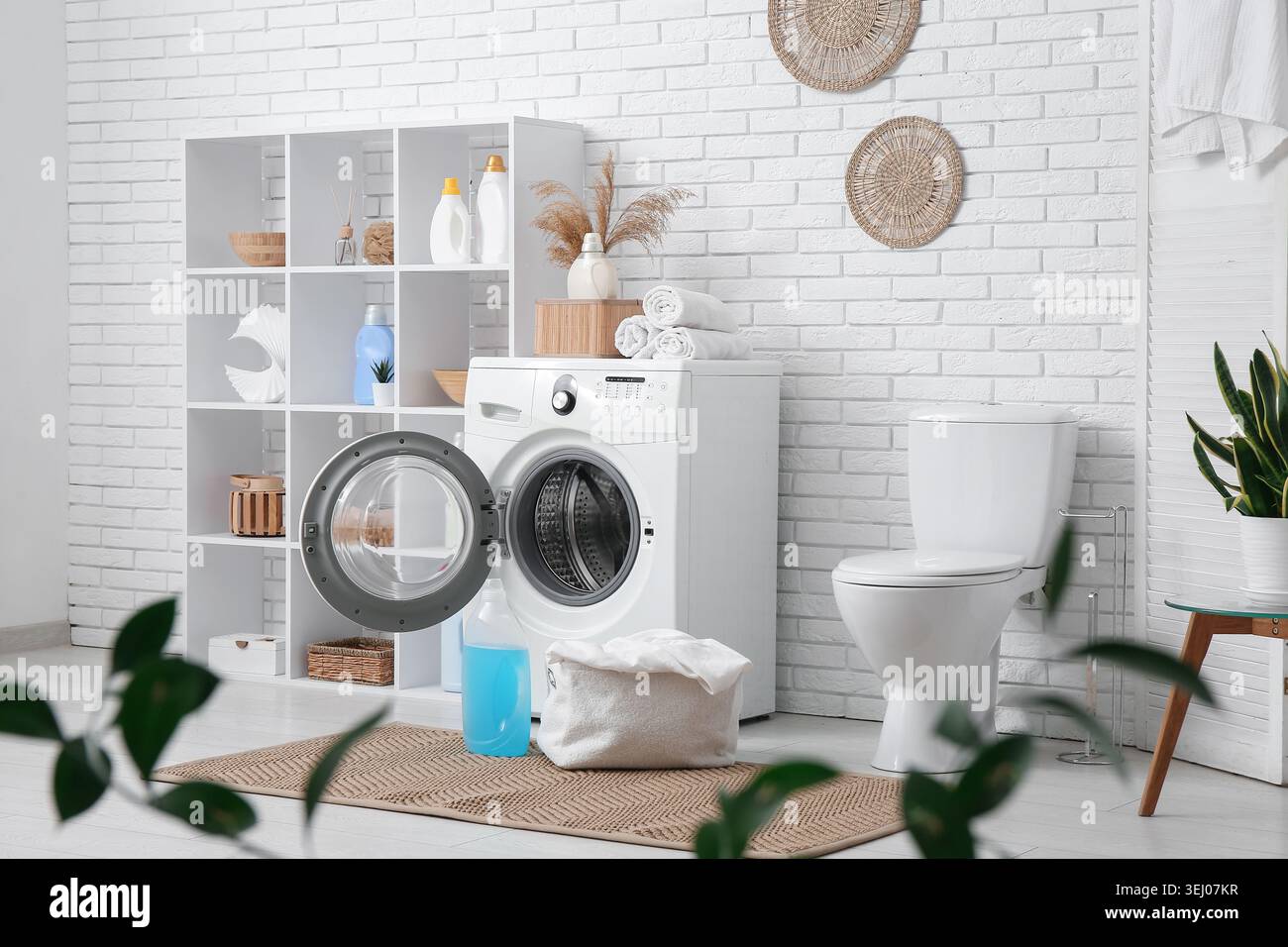Stylish laundry room with modern washing machine, shelving unit, toilet ...