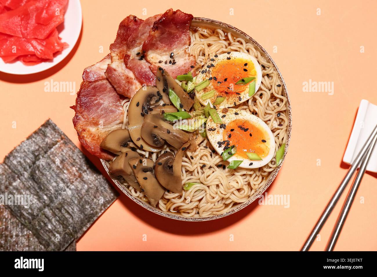 Bowl of ramen noodle soup with bacon, mushrooms and seaweed sheets on ...
