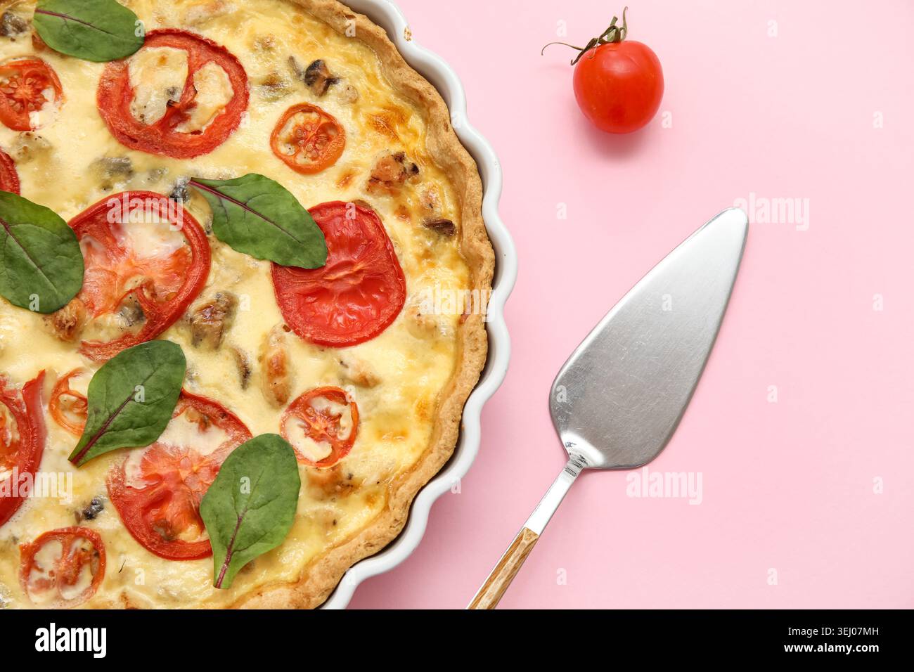 Delicious tomato tart with spinach leaves on pink background, closeup ...