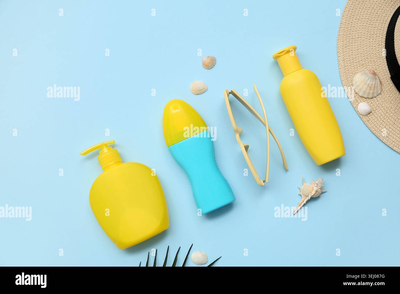 Composition with bottles of sunscreen cream, sunglasses, palm leaf and ...
