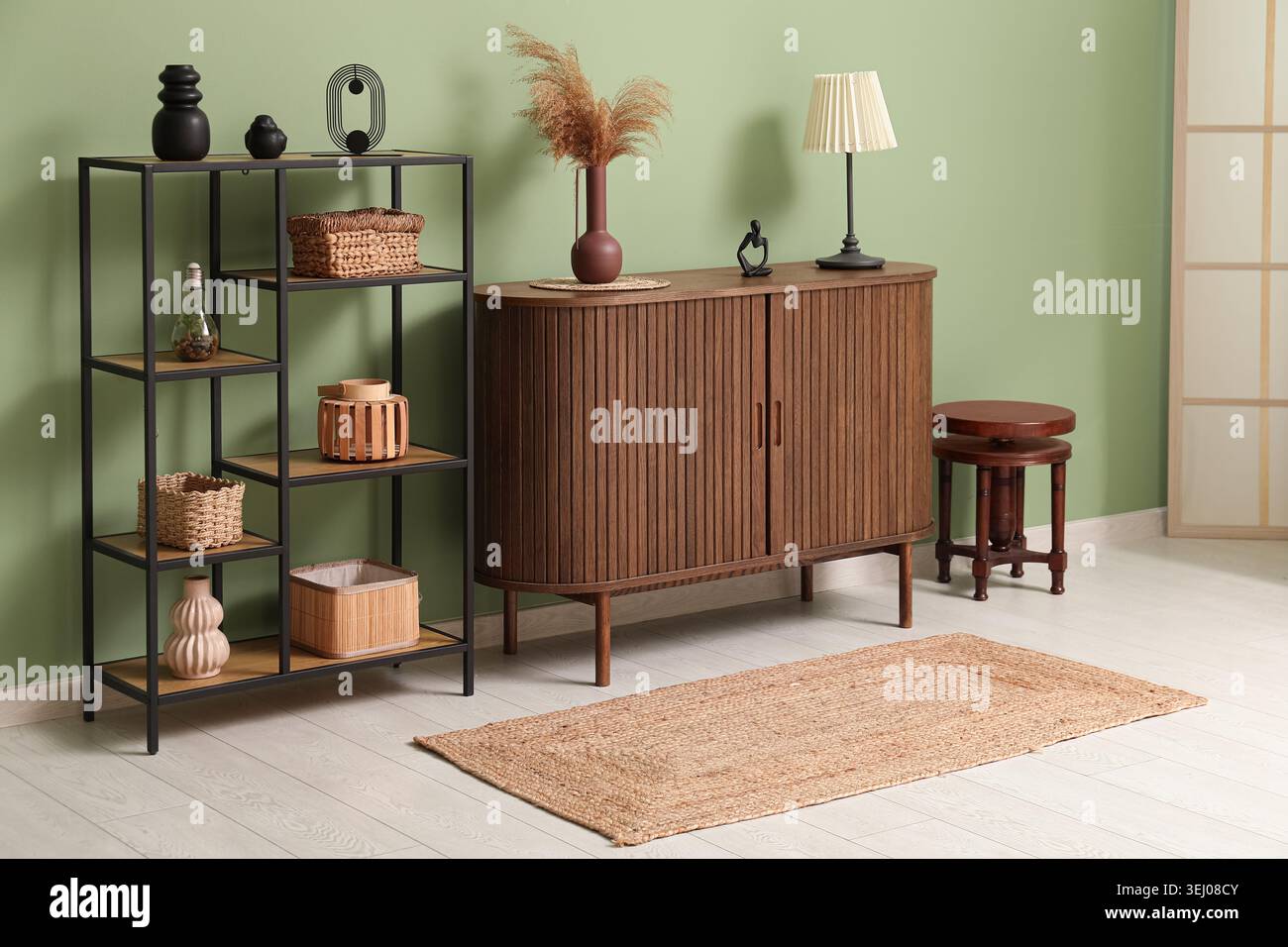 Dark wooden chest of drawers with lamp and vase of pampas grass near ...