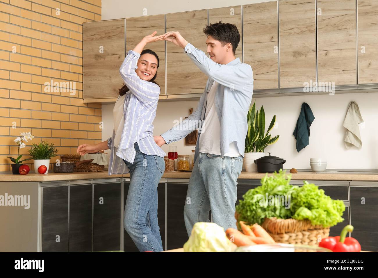 Happy dancing young couple in kitchen Stock Photo - Alamy