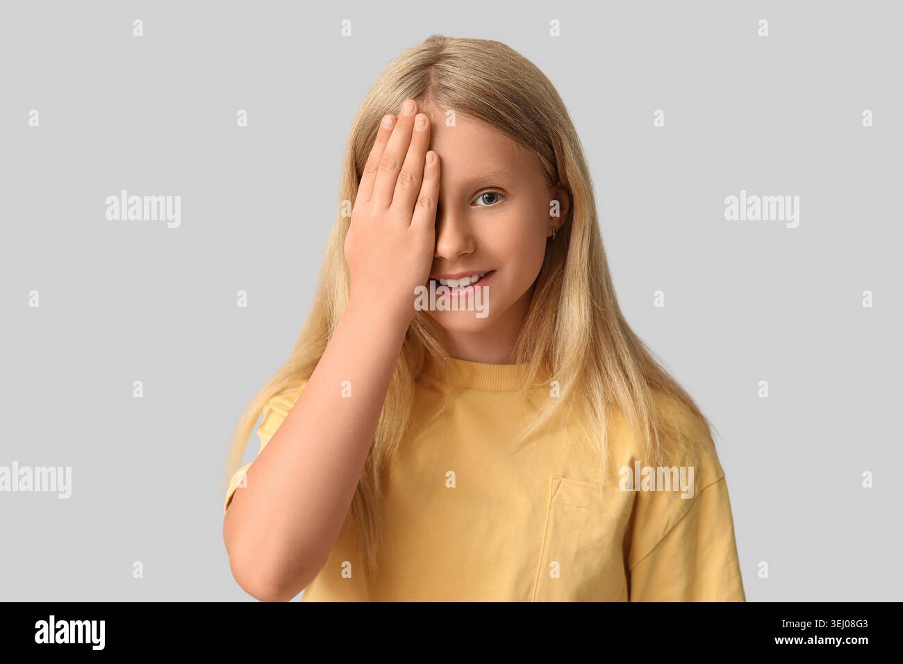 Teenage girl checking her eyesight on light background. Children's Eye ...