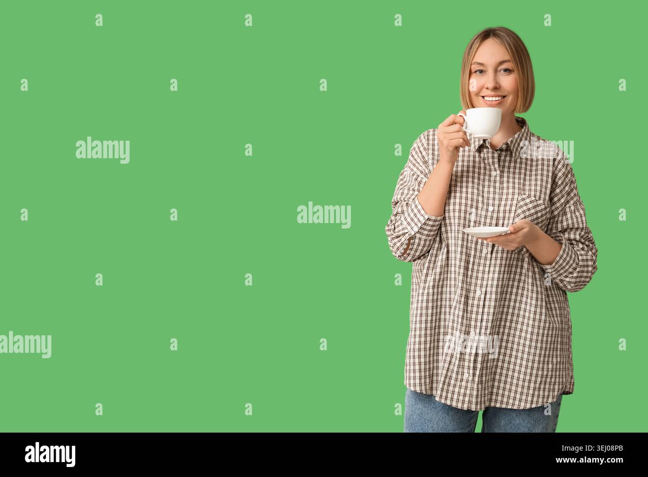 Happy adult woman with cup of coffee on green background Stock Photo ...