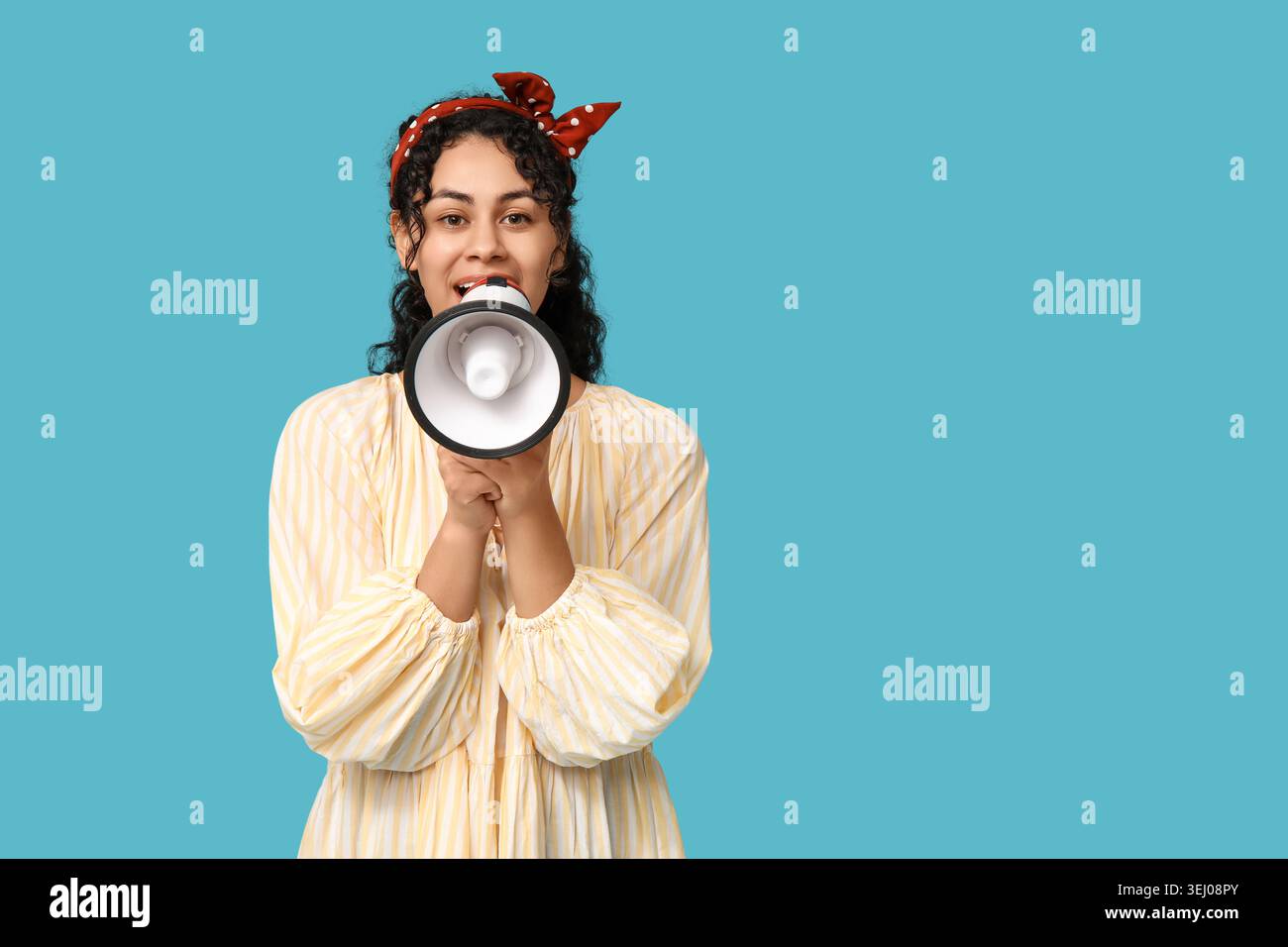 Young African-American woman with megaphone on blue background Stock ...