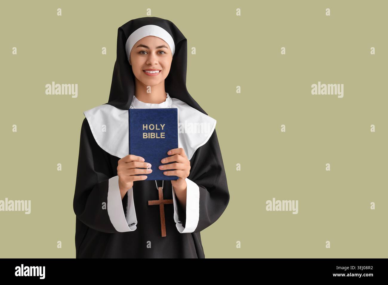 Young nun with Bible on green background Stock Photo - Alamy