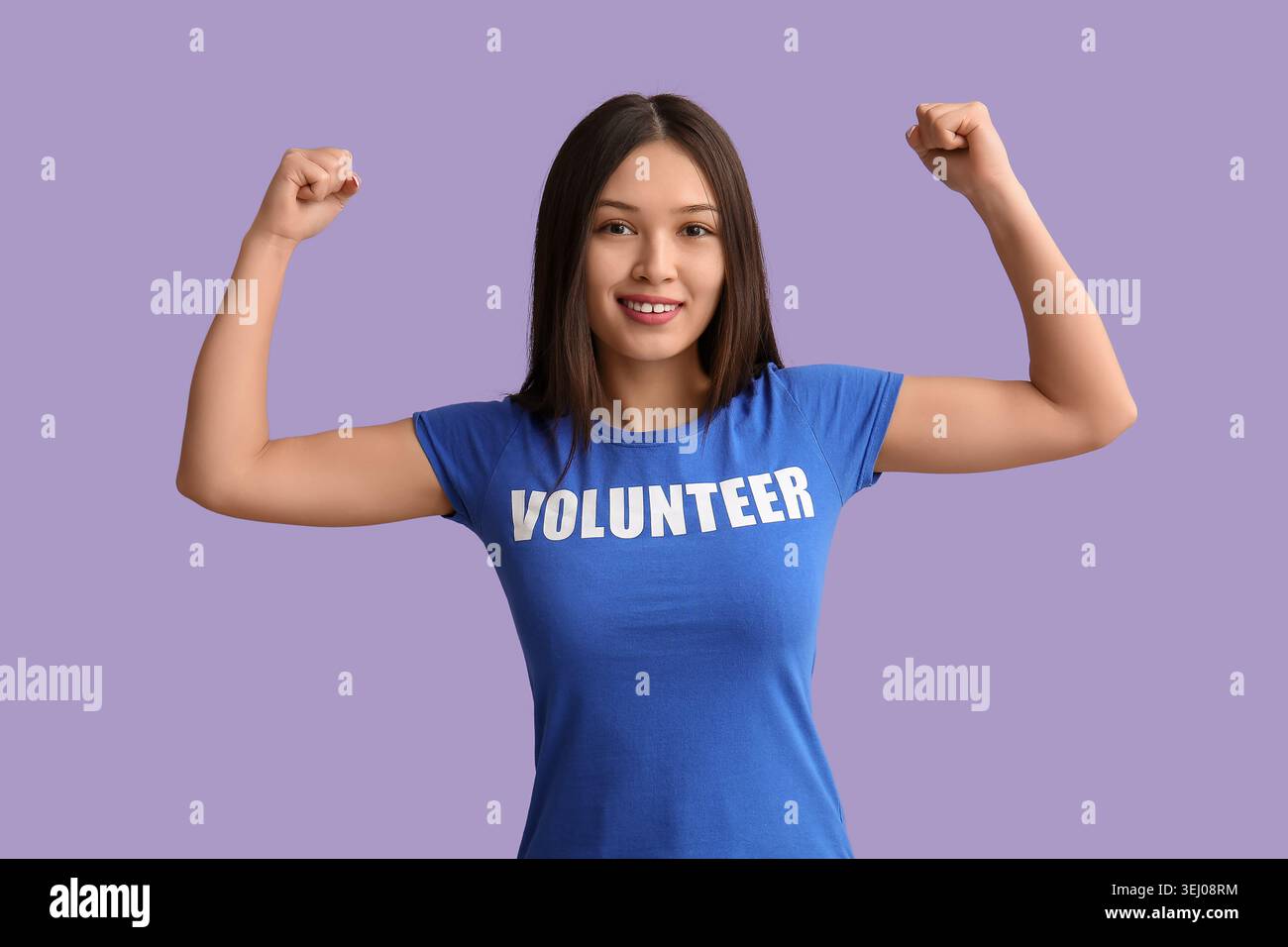 Young female volunteer showing muscles on lilac background Stock Photo ...