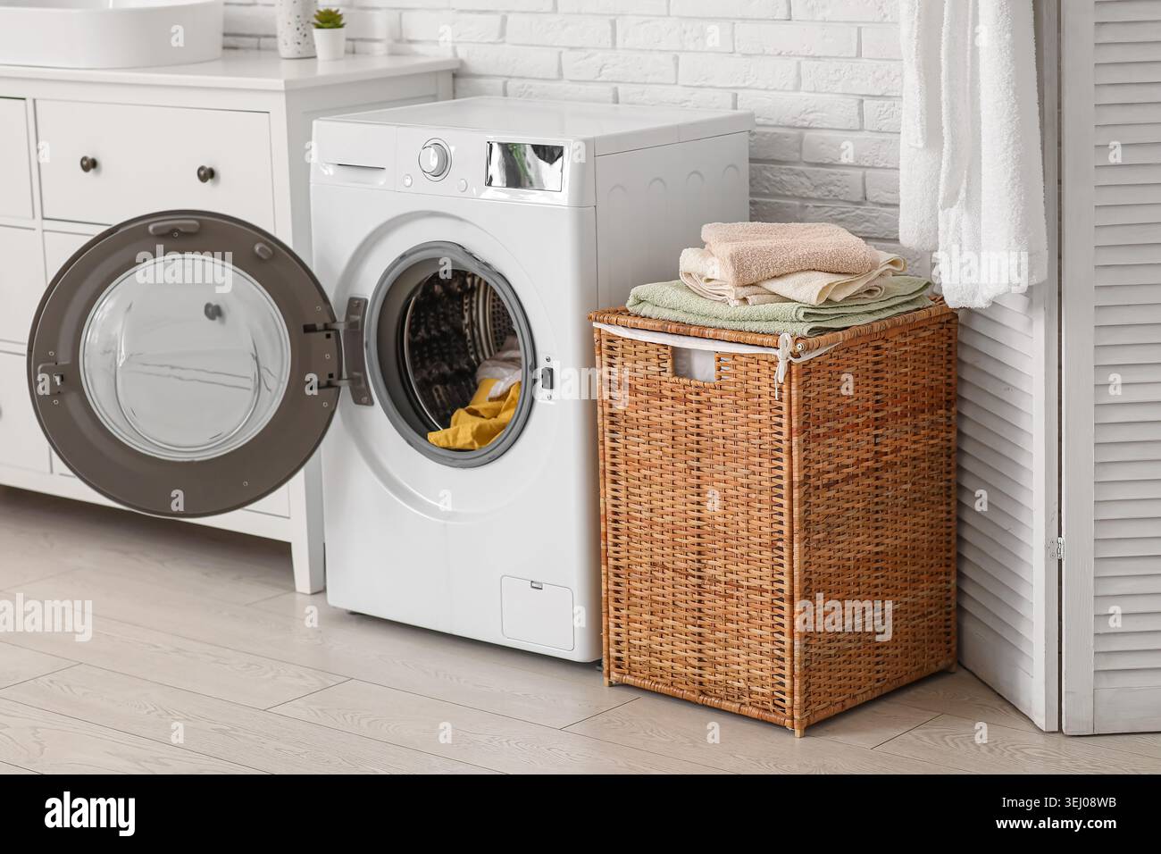 Washing machine and basket with dirty clothes in laundry room Stock ...