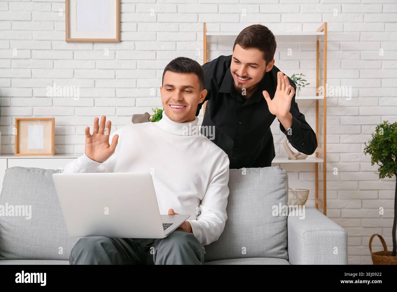 Young men with laptop video chatting on online date at home Stock Photo ...