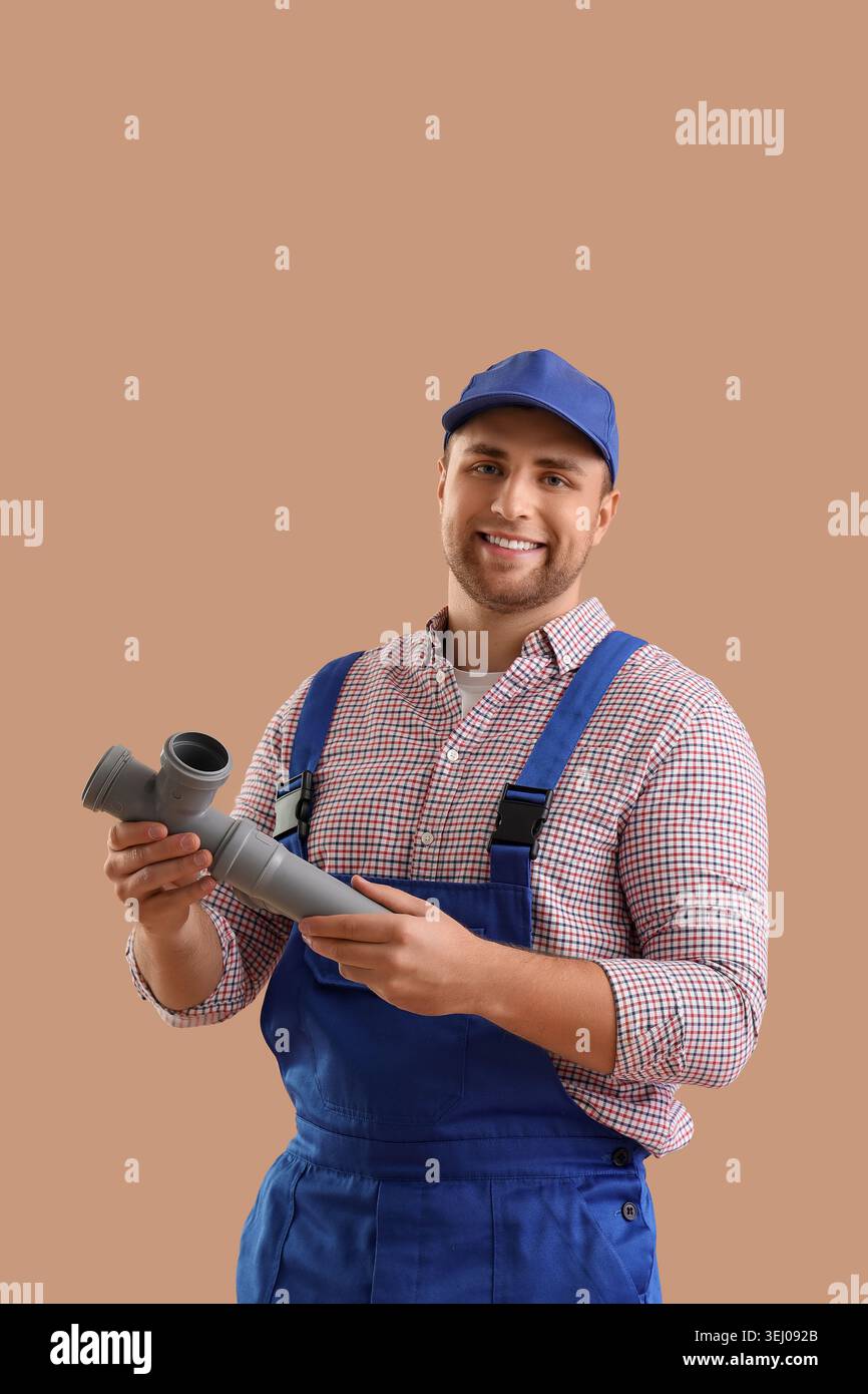 Male plumber with pipe on brown background Stock Photo - Alamy