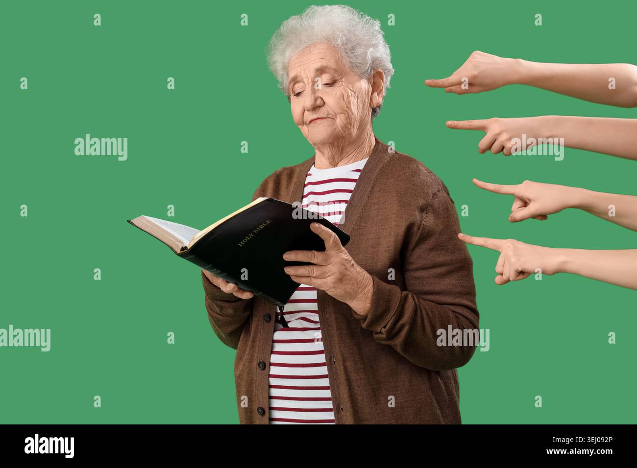 People pointing at senior woman with Holy Bible on green background ...