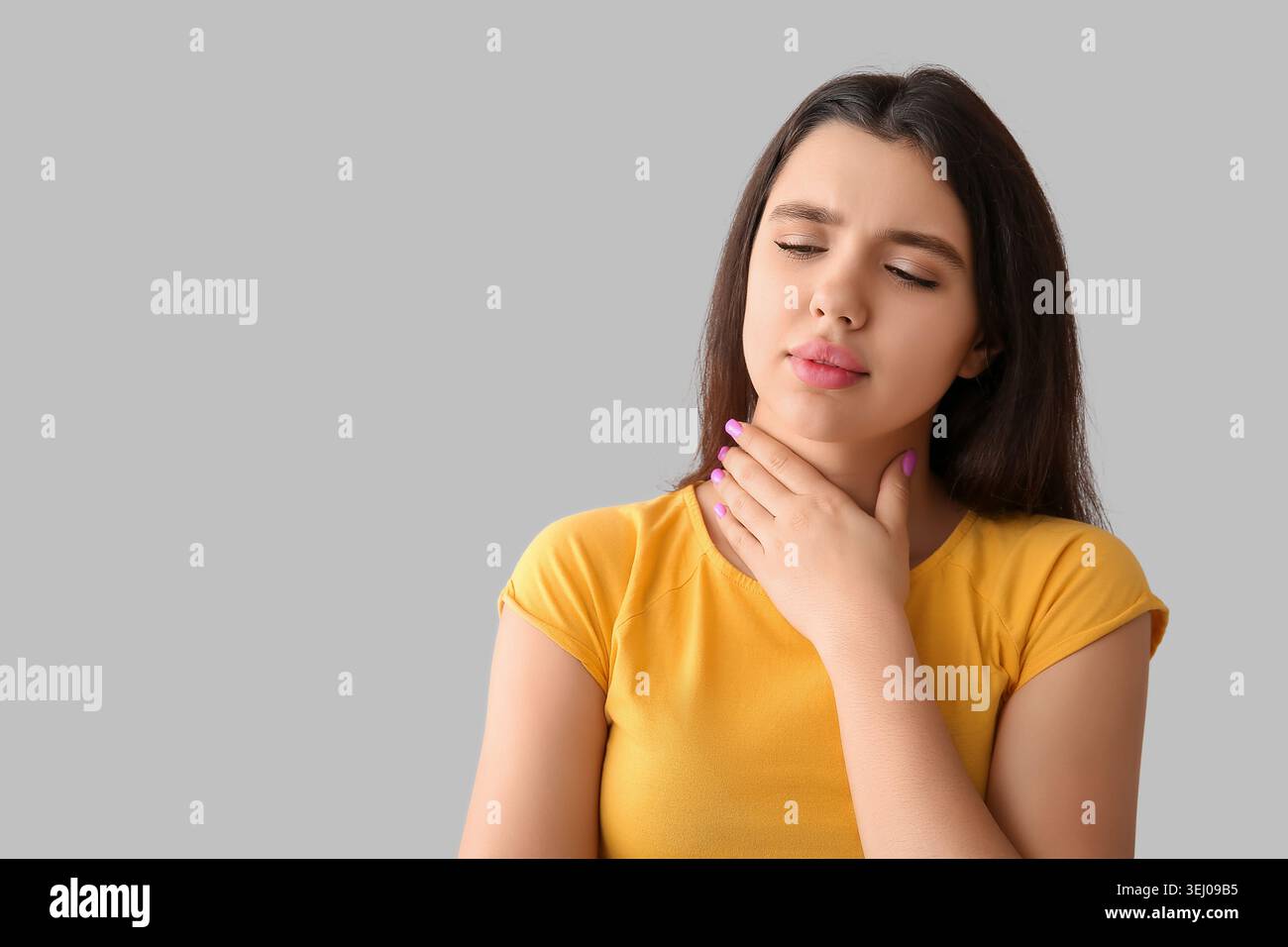 Young woman with thyroid gland problem on grey background Stock Photo ...
