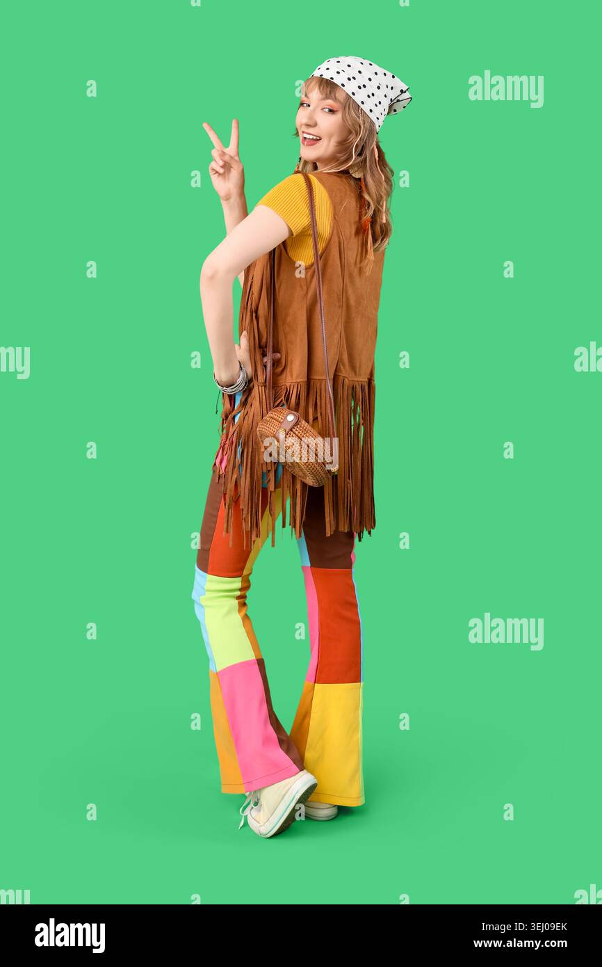 Female hippie showing victory gesture on green background Stock Photo ...