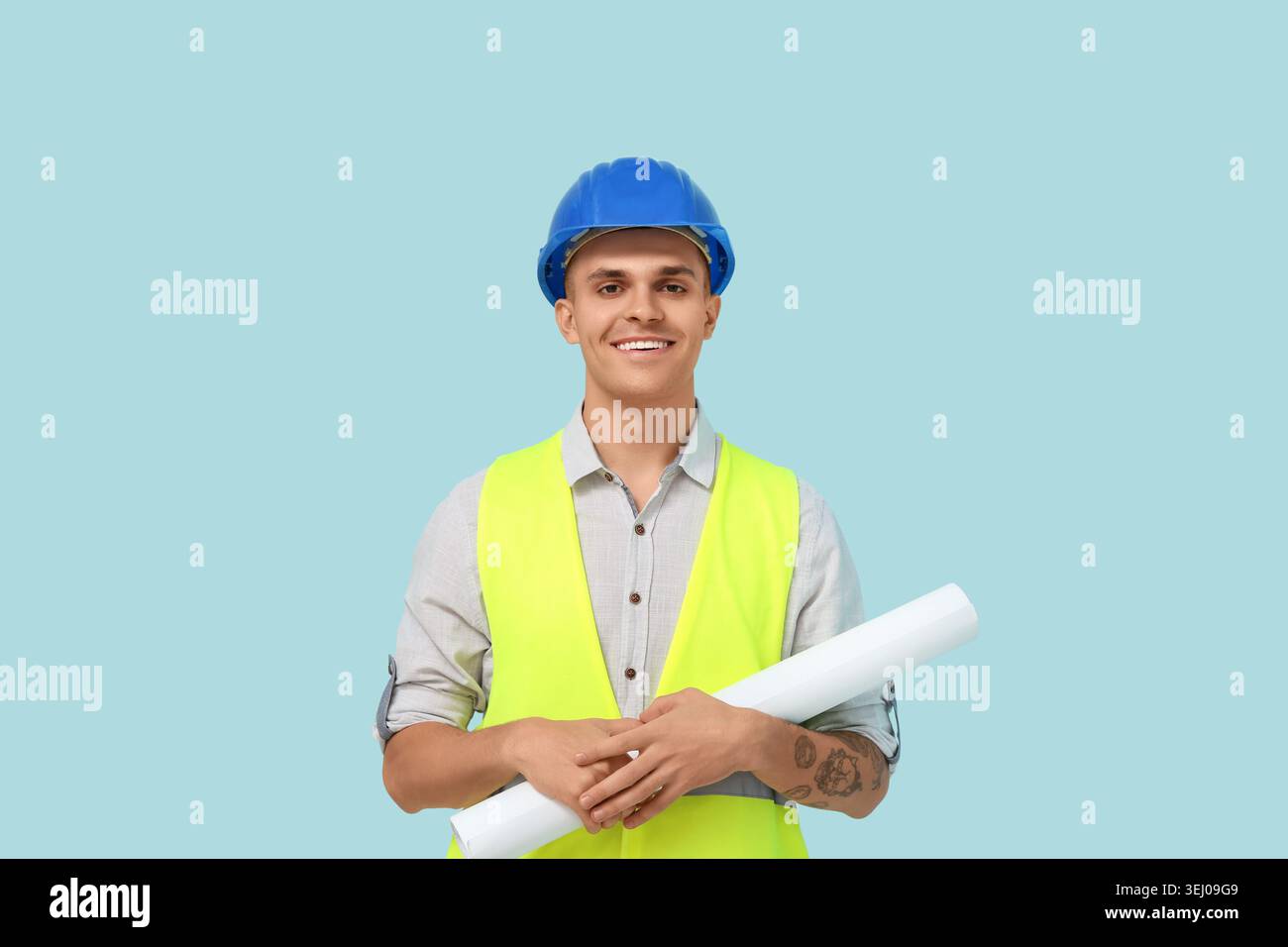 Young male engineer with blueprint on blue background Stock Photo - Alamy
