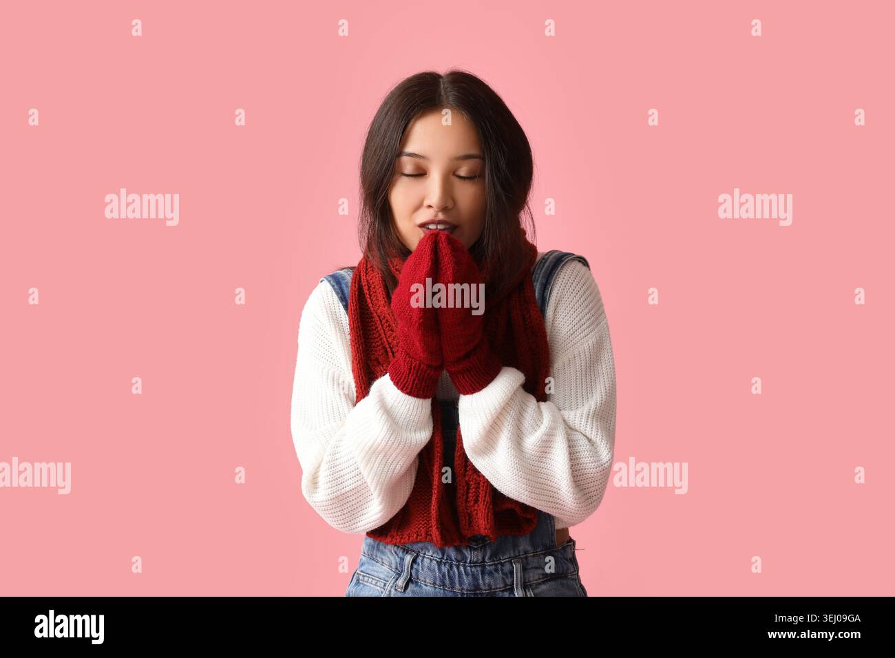 Beautiful frozen Asian woman in warm scarf and gloves on pink ...