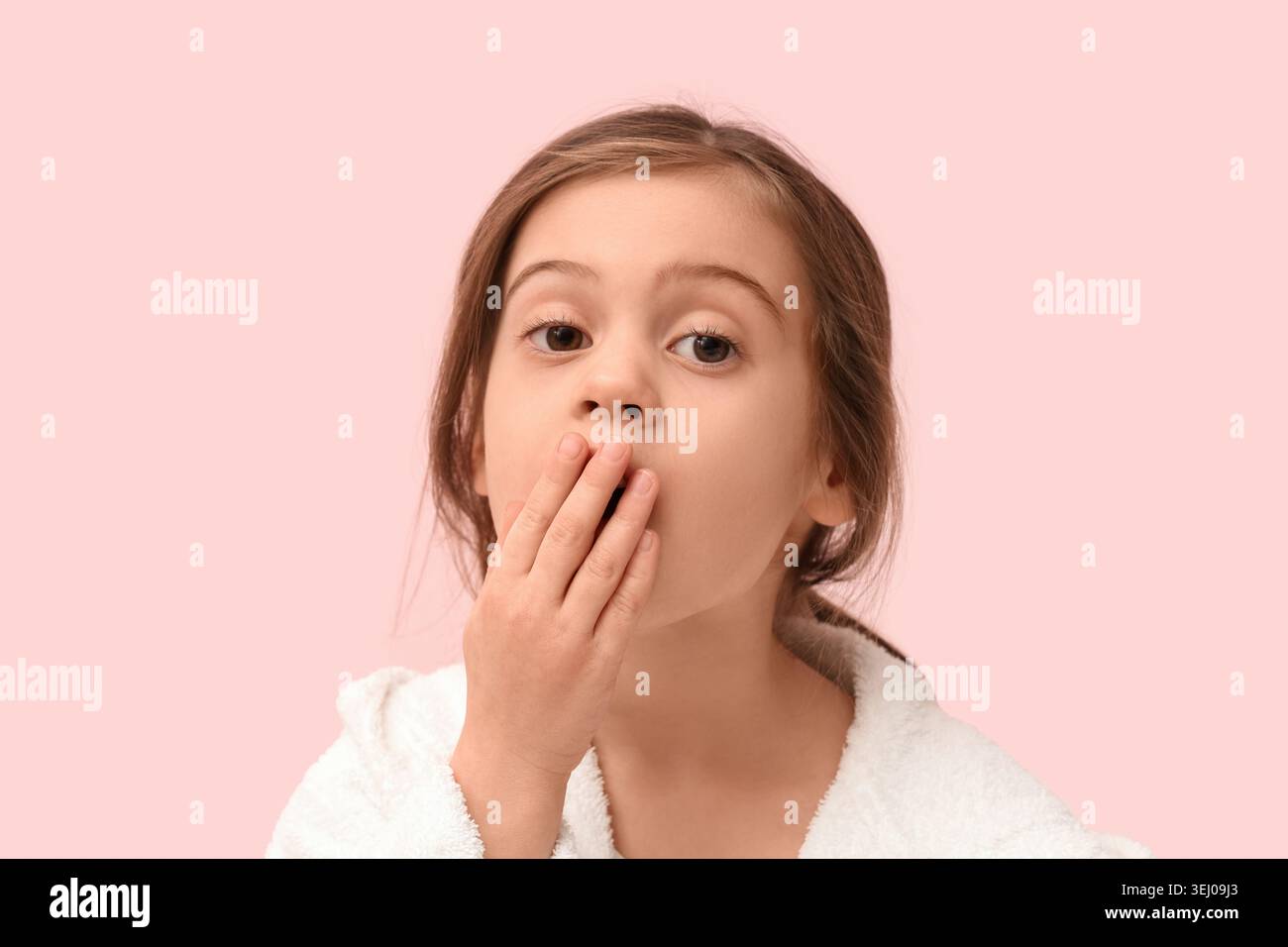 Cute little girl in bathrobe yawning on pink background Stock Photo - Alamy