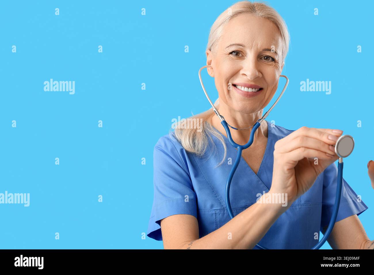 Mature doctor with stethoscope on blue background, closeup Stock Photo ...