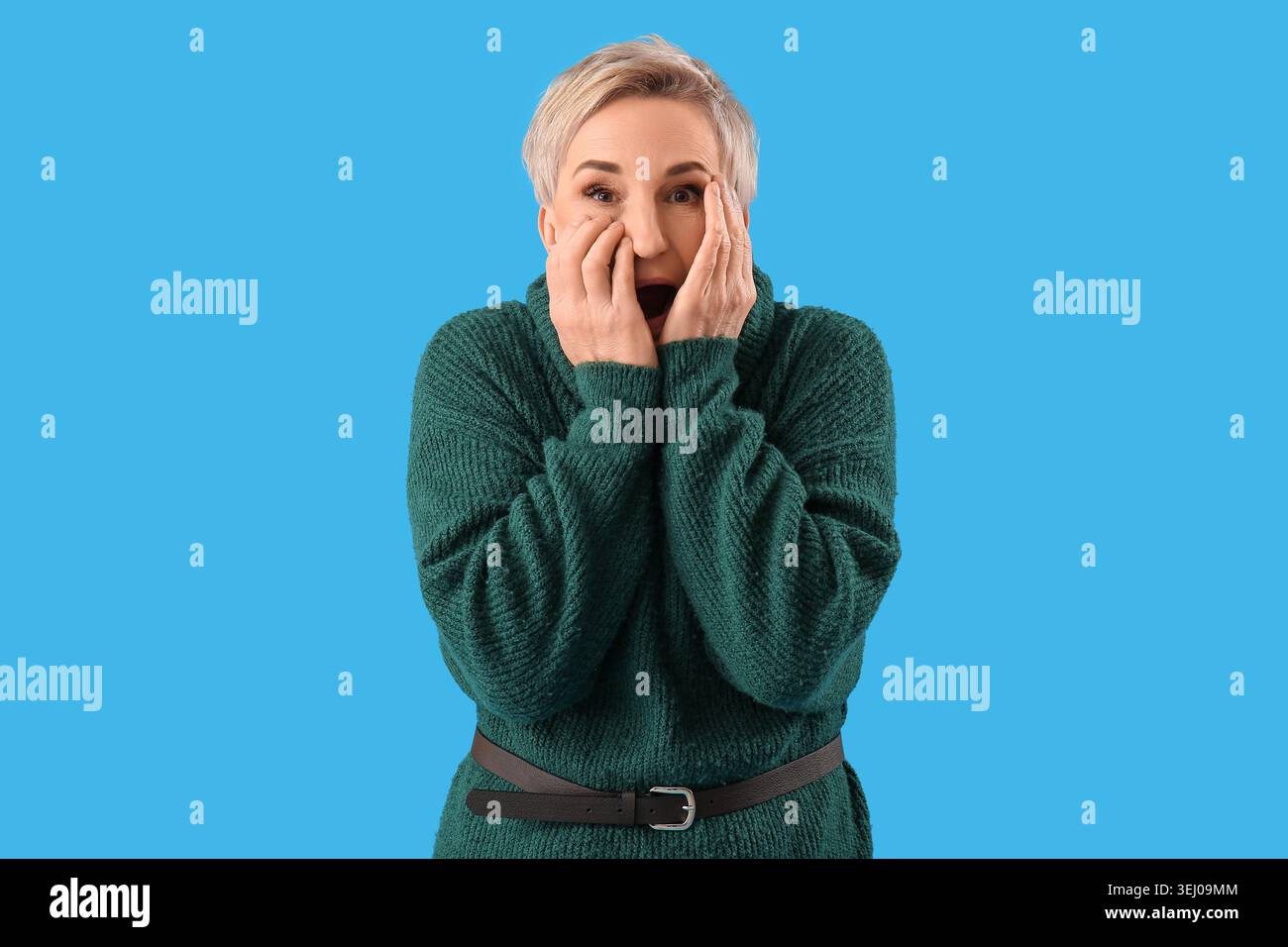 Scared mature woman on light blue background Stock Photo - Alamy