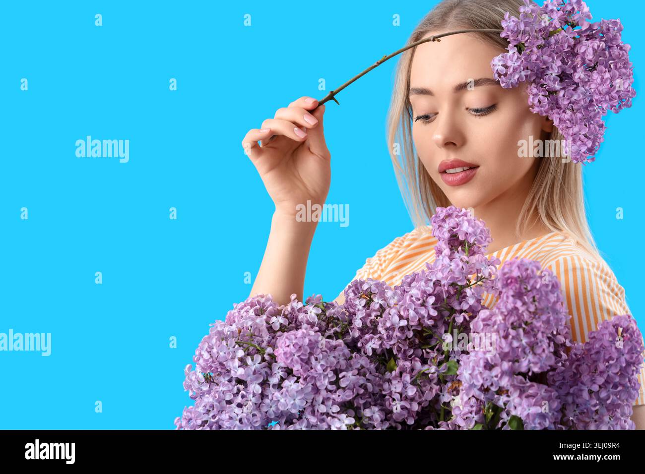 Young woman with lilac flowers on blue background, closeup Stock Photo ...