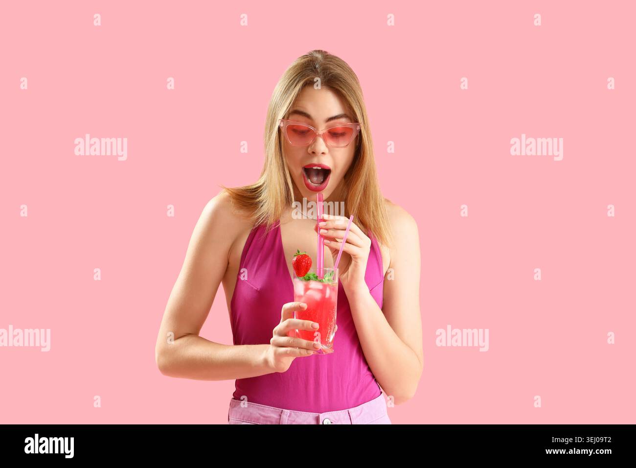 Beautiful shocked young woman in sunglasses with tasty strawberry ...