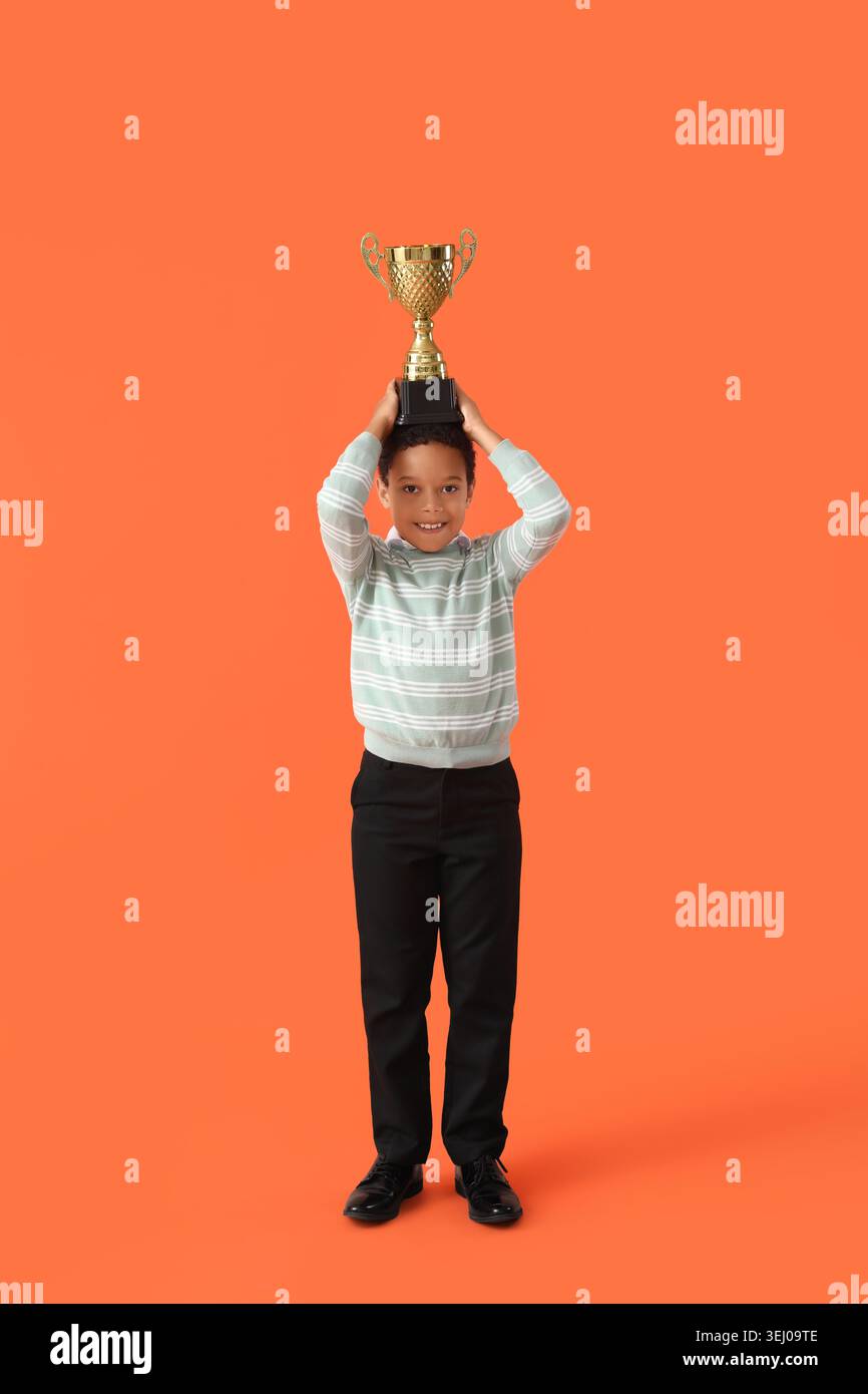 Smart African-American schoolboy in stylish uniform with prize cup on ...